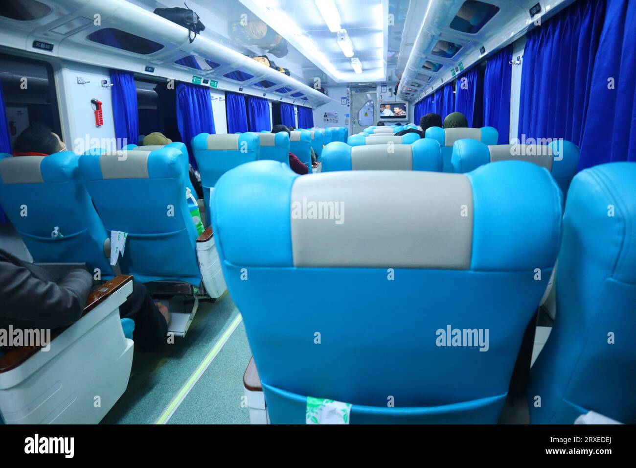 Executive class train interior with blue seats, armrests, luggage racks ...