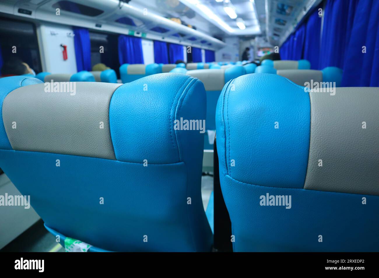 Executive class train interior with blue seats, armrests, luggage racks ...