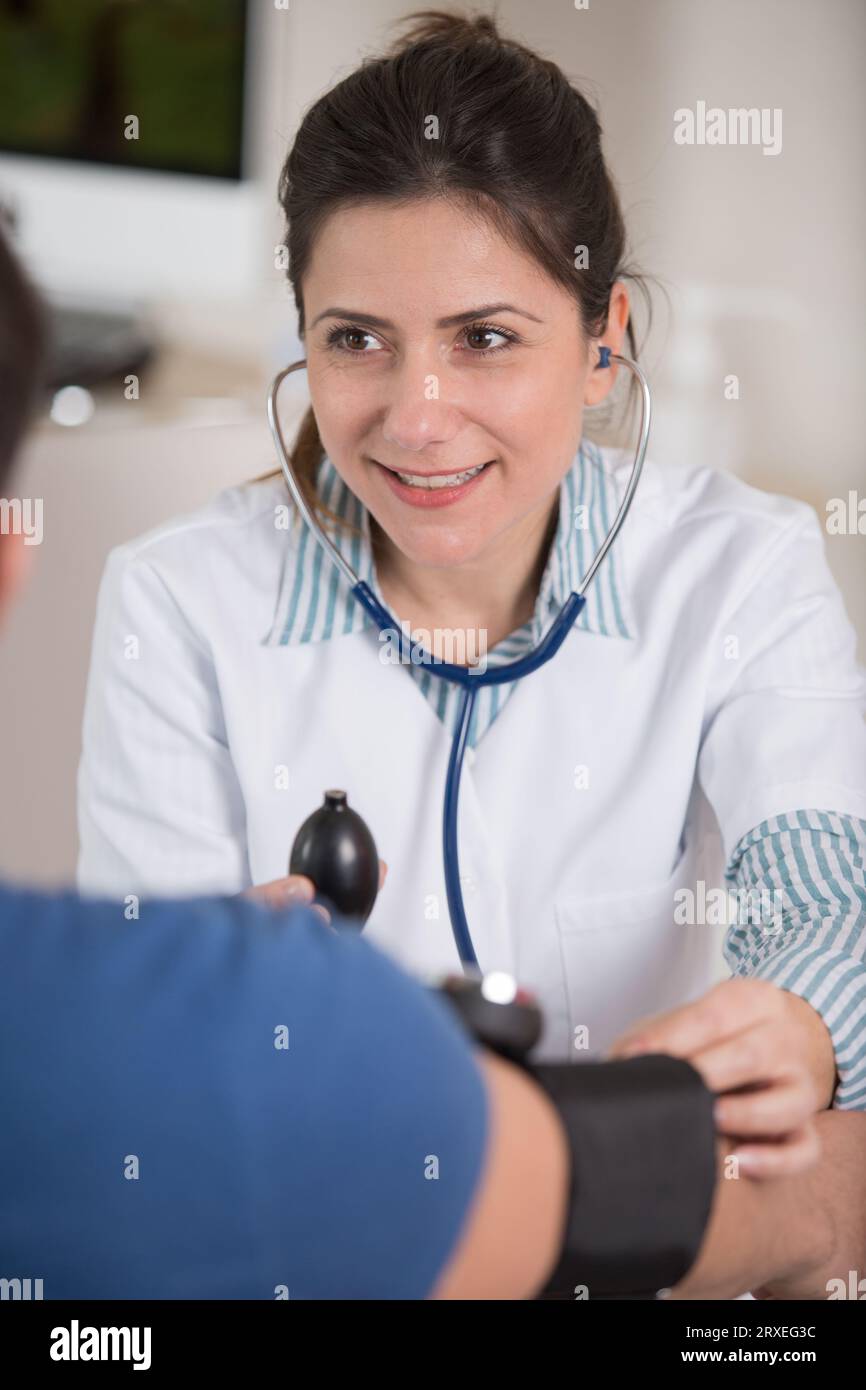nurse measuring blood pressure of man indoors Stock Photo - Alamy