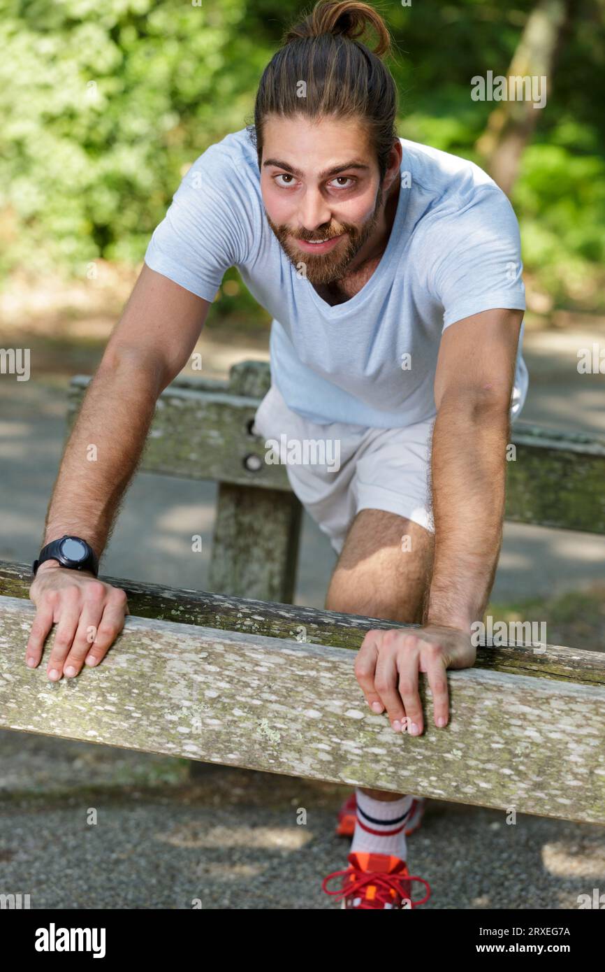 young fit man stretching legs outdoors doing forward lunge Stock Photo ...