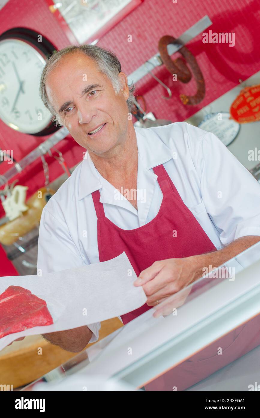 Old butcher serving a client Stock Photo - Alamy