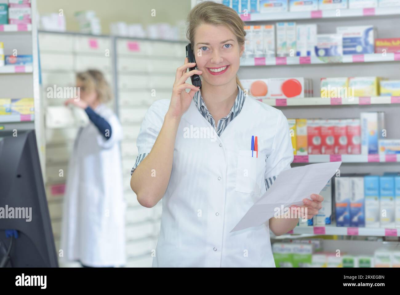 female pharmacist on phone call reaching medication Stock Photo - Alamy