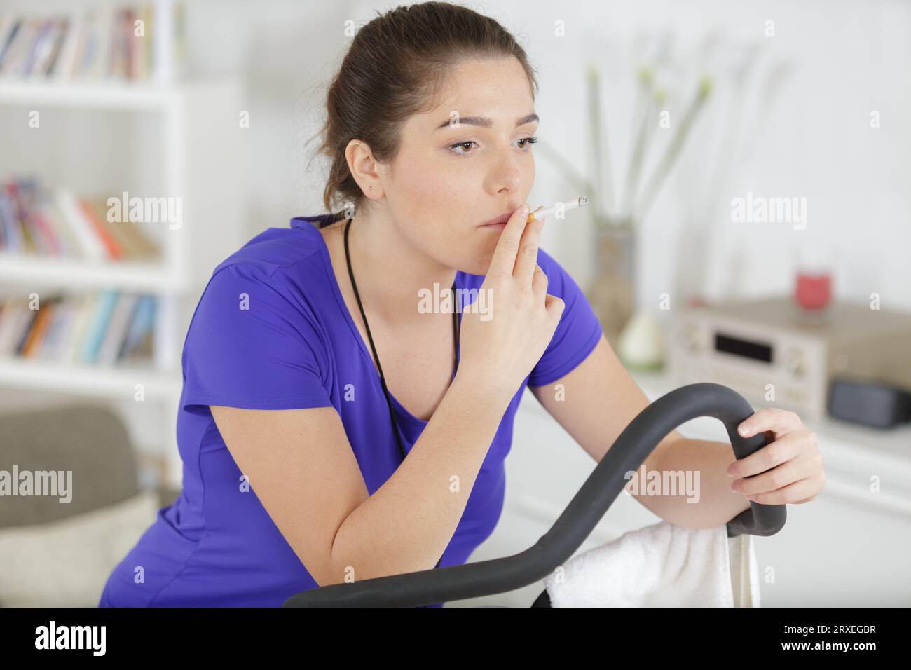 young woman smoking a cigarette while exercising Stock Photo - Alamy
