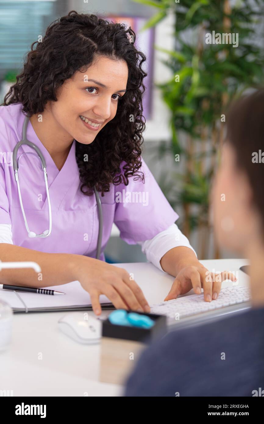 female medic typing during appointment with patient Stock Photo - Alamy