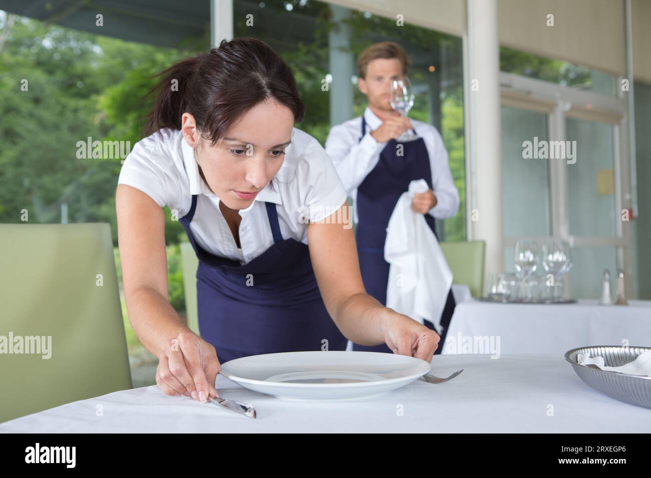 waitress setting the table in restaurant Stock Photo - Alamy