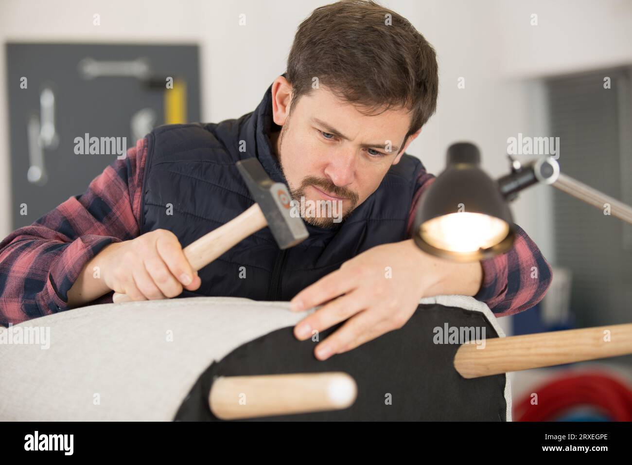 man hammering chair leg into place Stock Photo - Alamy