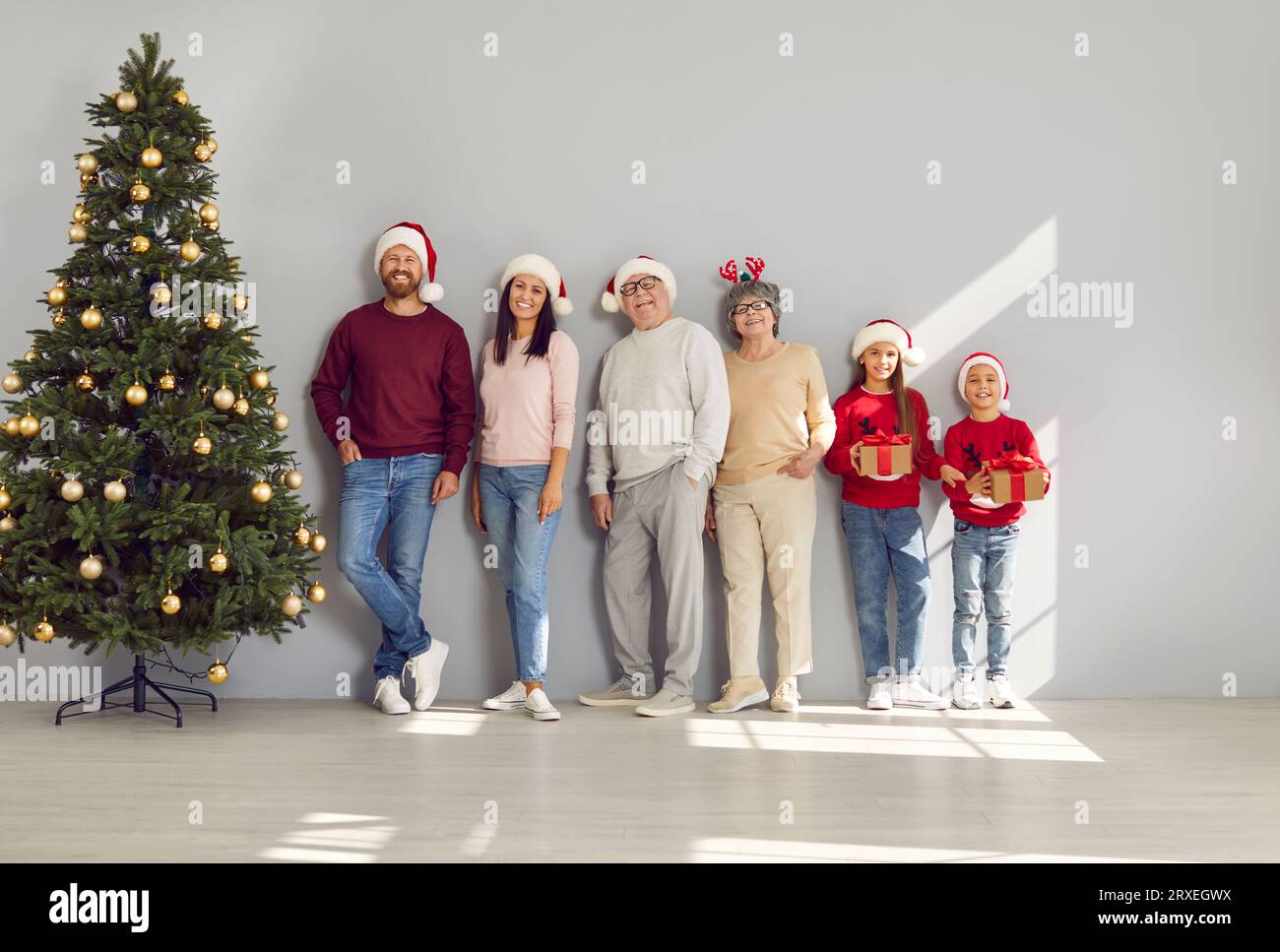 Happy family in Christmas hats line up in order of height, from ...