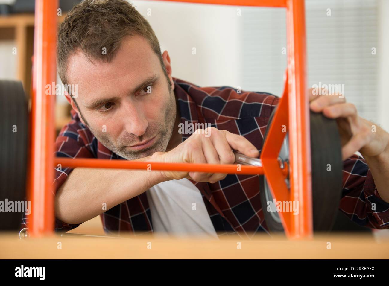 handyman using a spanner to assemble a trolley Stock Photo - Alamy