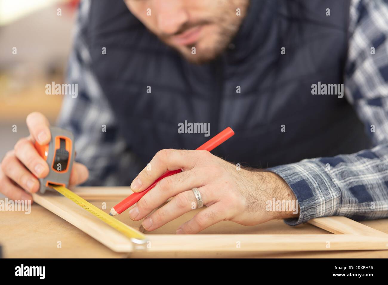craftsman measuring wooden picture frame Stock Photo - Alamy