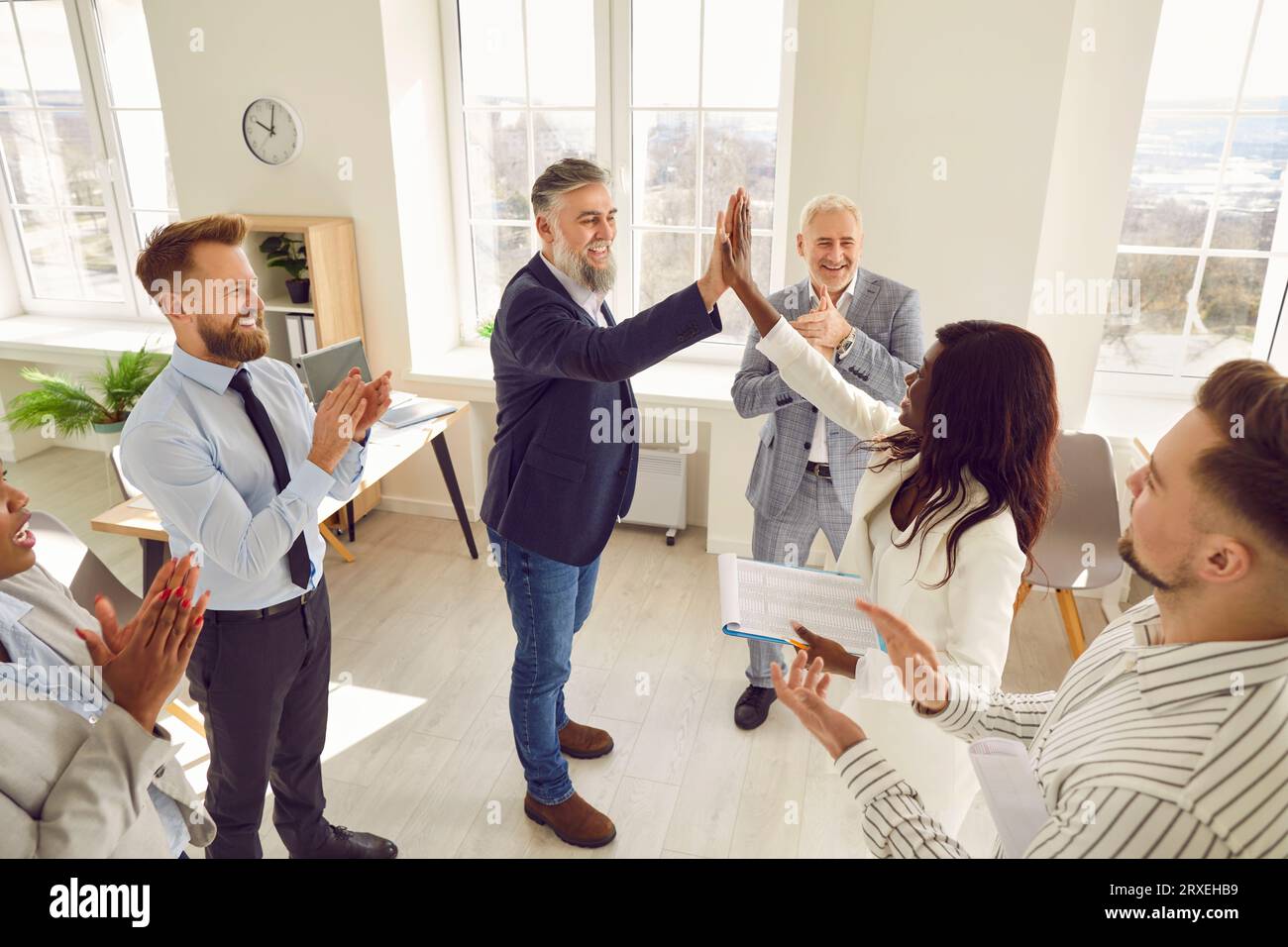 Happy colleagues giving high five at meeting at office, celebrating ...