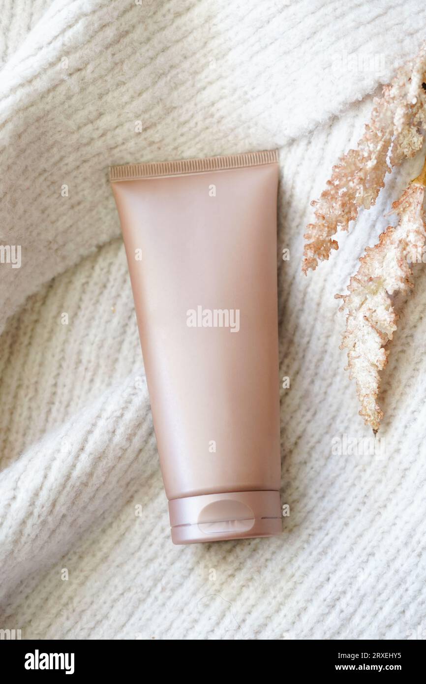 Cosmetic Cream beige tube mockup with dry spikelets on light textile ...