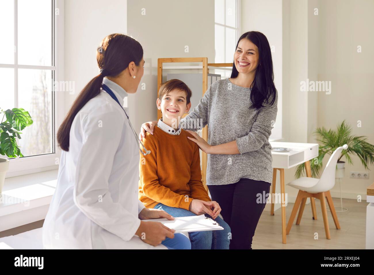 Portrait of a child boy patient with mother talking with paediatrician ...