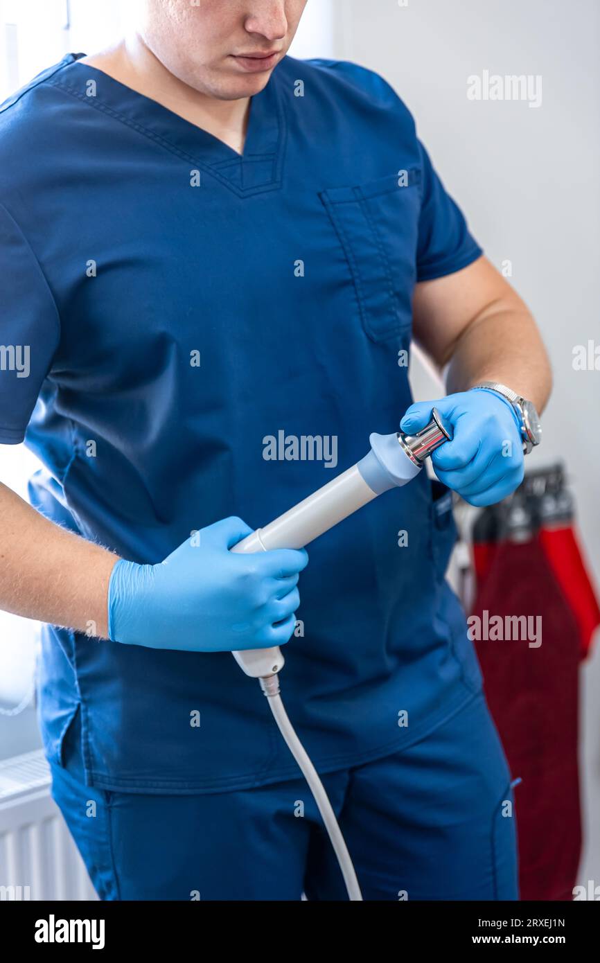 Shock wave therapy device with male doctor hands in rubber gloves Stock ...