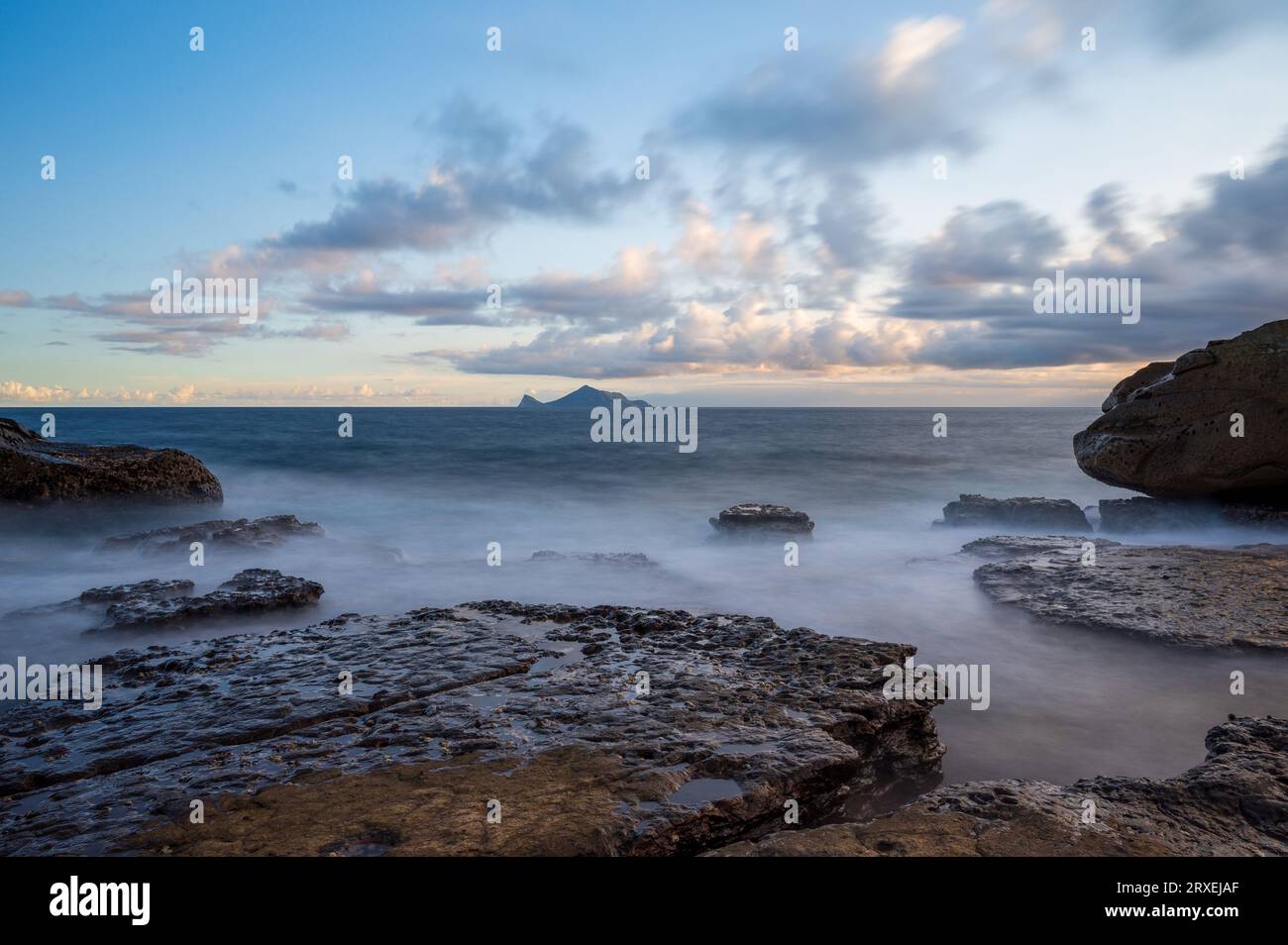 Blue sea and blue sky with changing white clouds. Small islands and ...