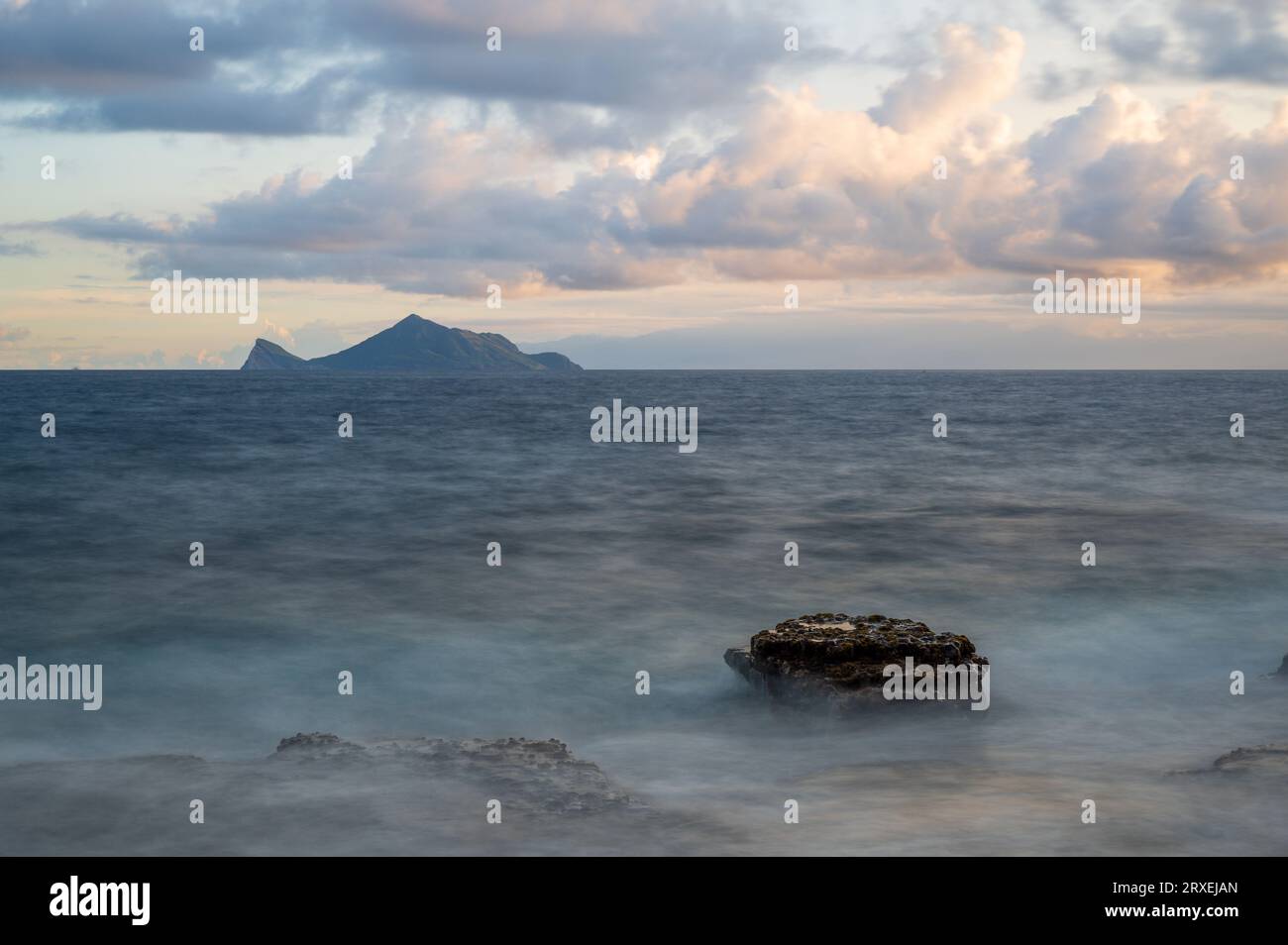 Blue sea and blue sky with changing white clouds. Small islands and ...