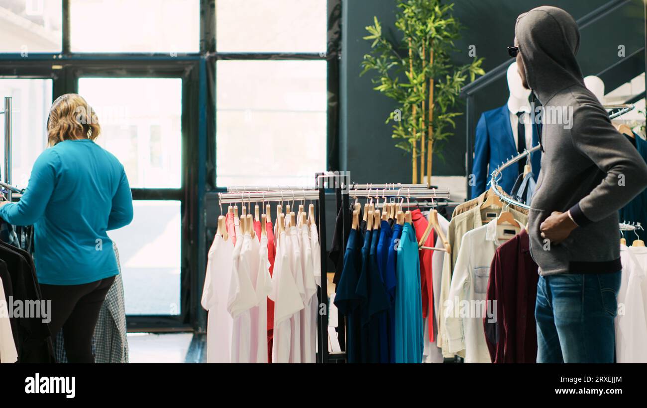 African american thief stole stylish clothes in clothing store, being ...