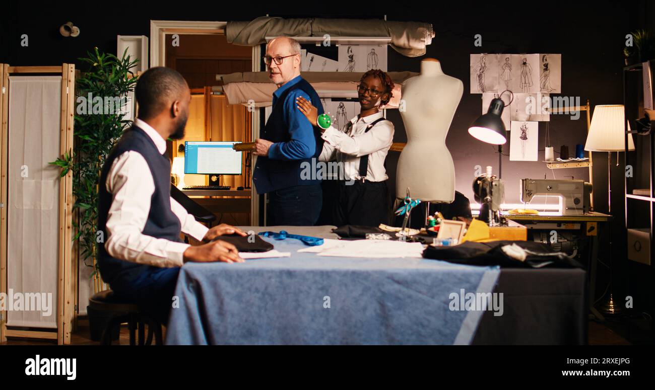 Old client fitting blazer in atelier, ensuring right body sizes at ...