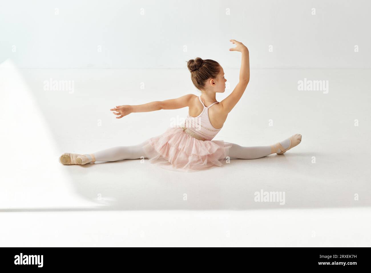 Back view portrait of small adorable ballerina dancer girl sits in ...