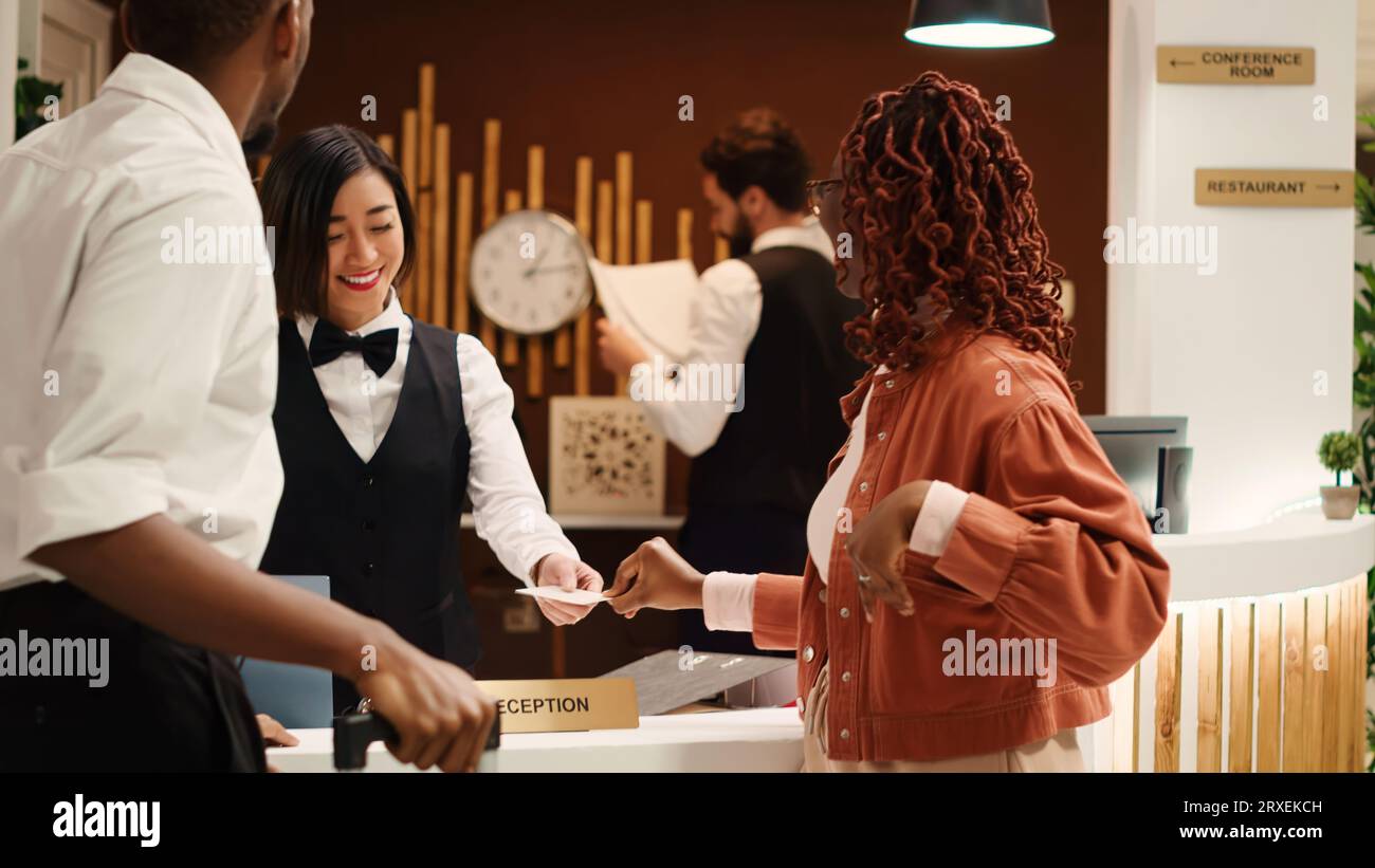 Tourists finishing vacation trip, handing out room card key to cheerful ...