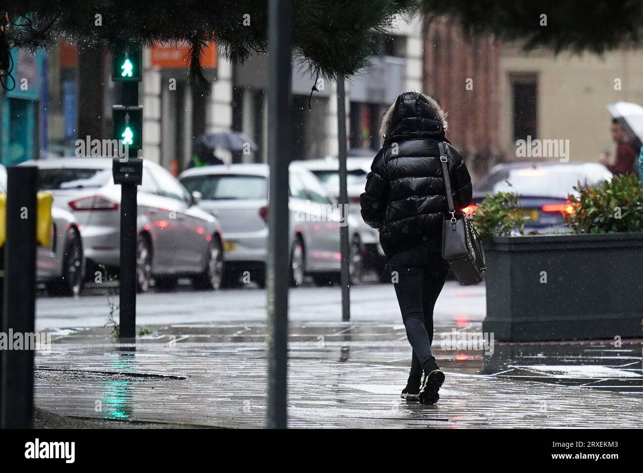 Commuters on their way to work protect themselves from heavy rain in ...