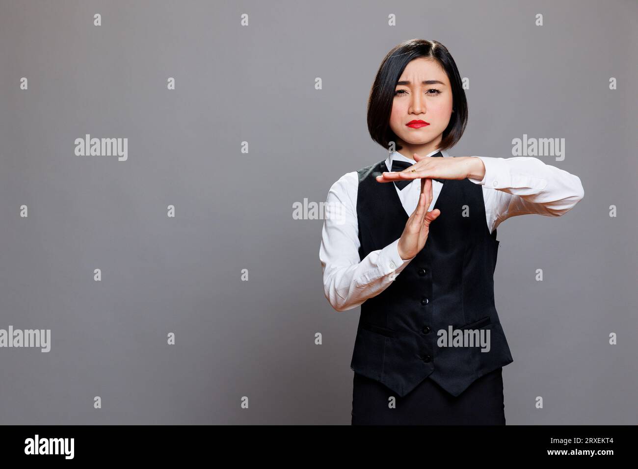 Confident asian waitress wearing uniform showing timeout sign with arms ...