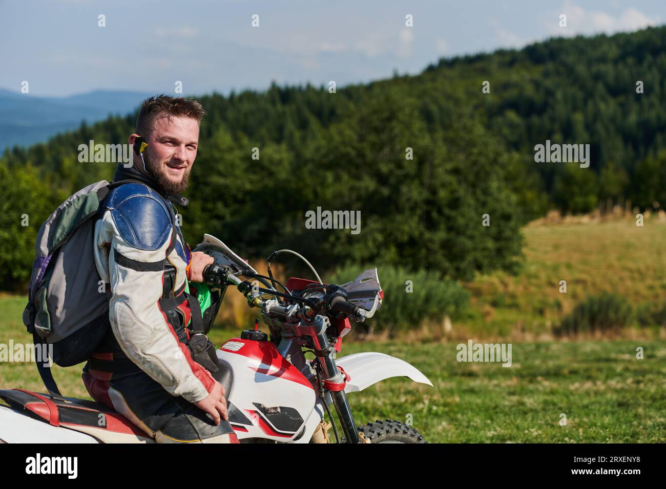 A professional motocross rider, fully geared up with helmet, gloves ...