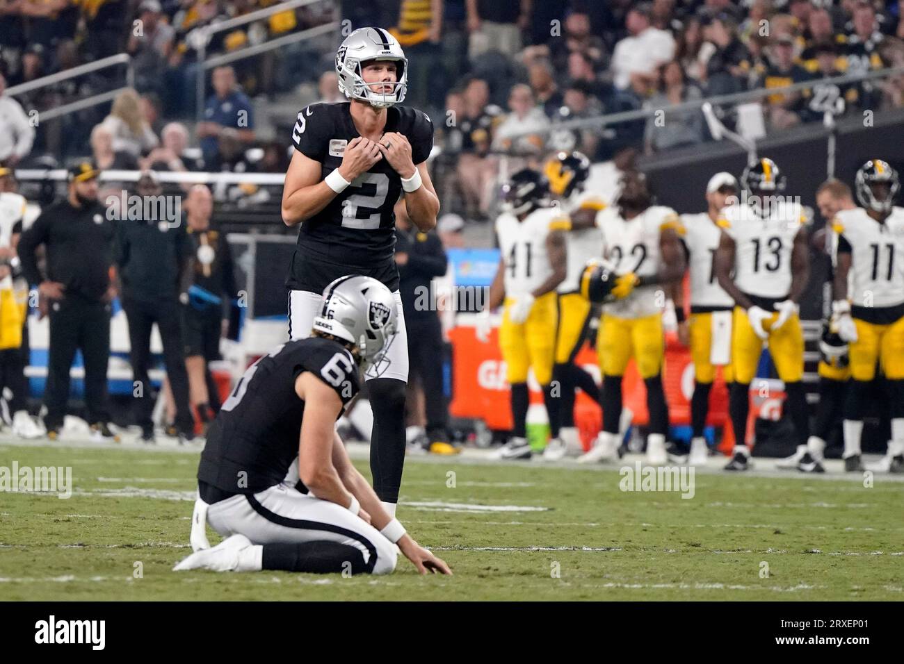 Las Vegas Raiders place kicker Daniel Carlson, top, gets set to kick a ...