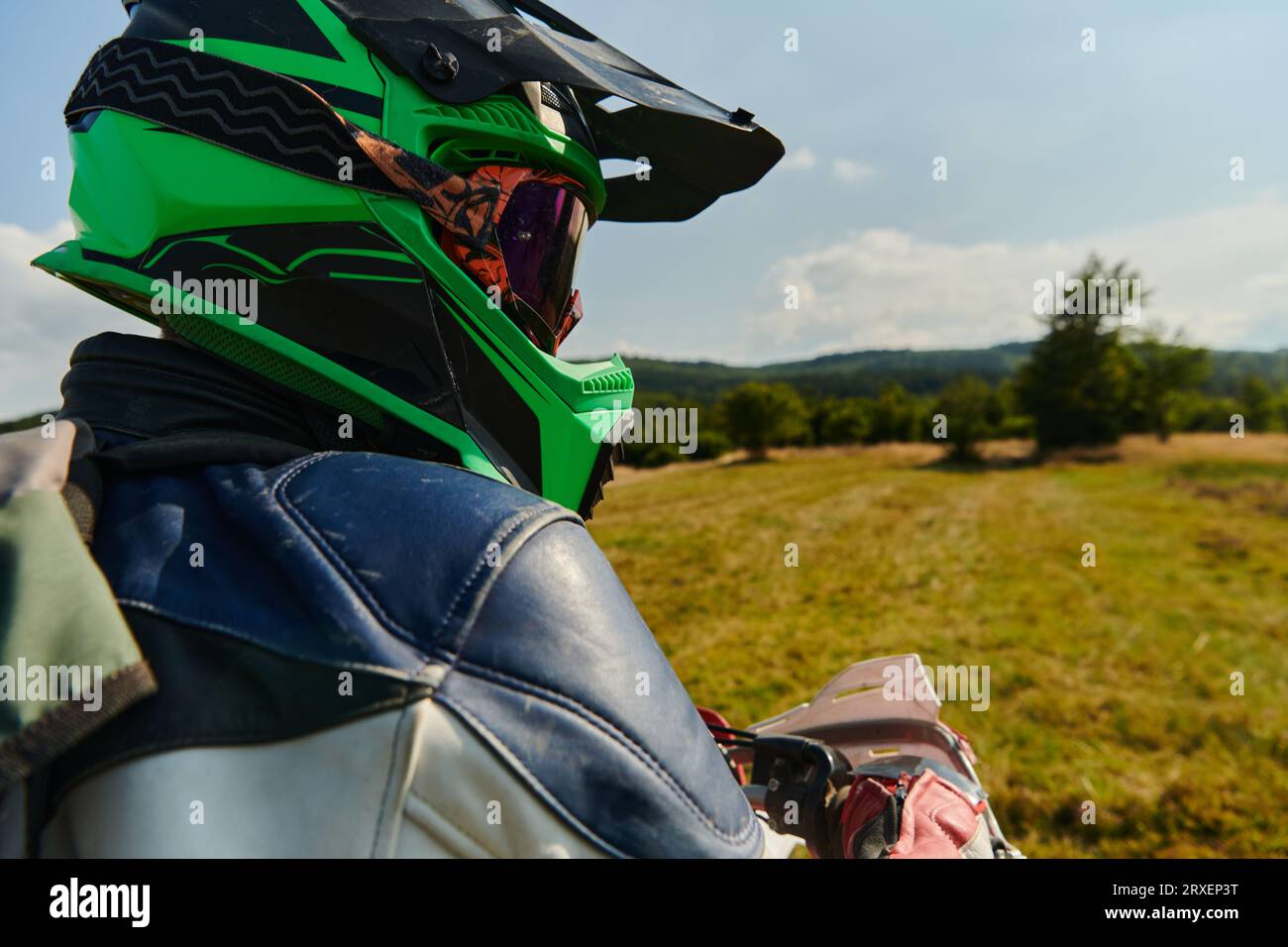 A professional motocross rider, fully geared up with helmet, gloves ...