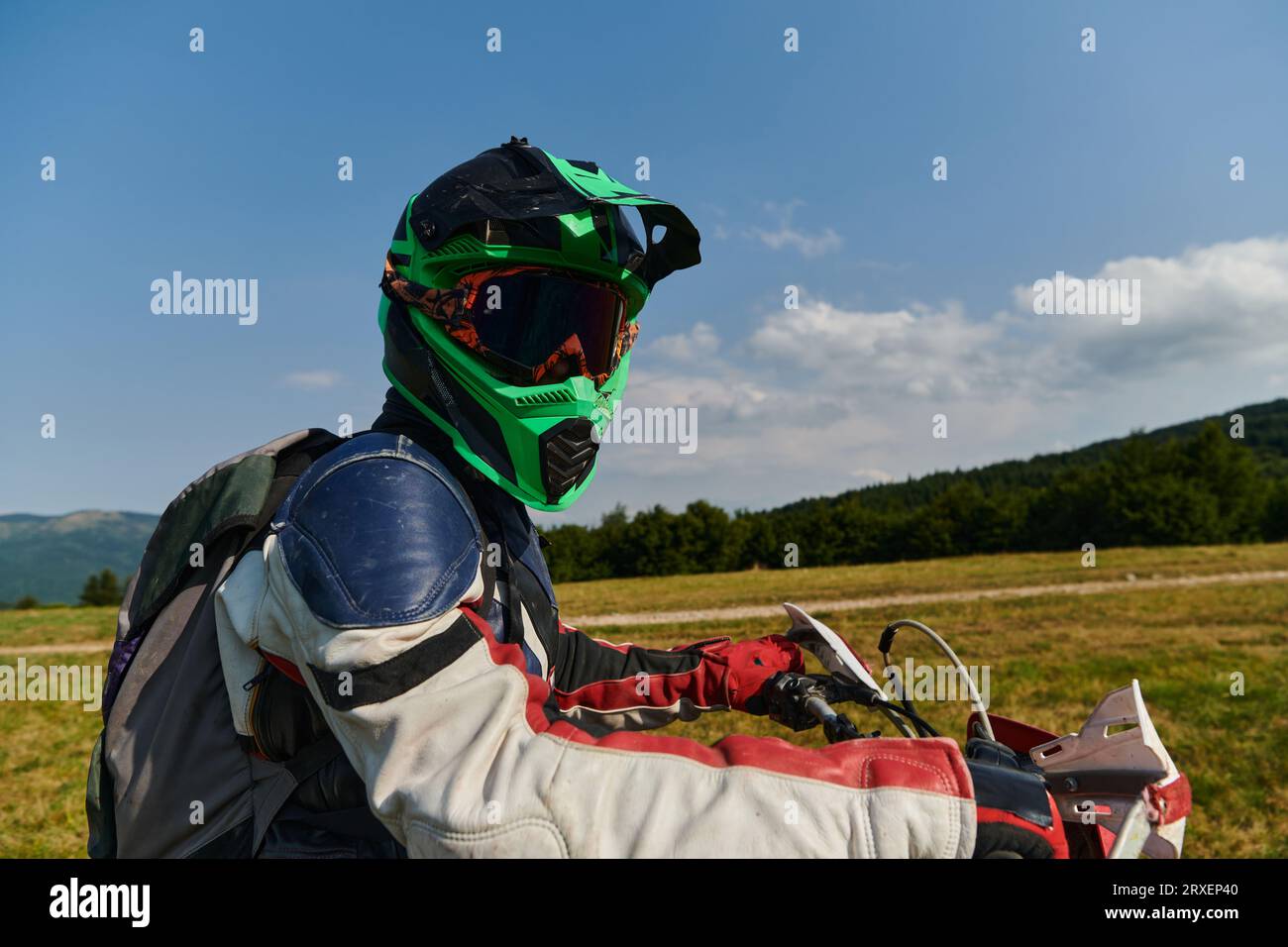 A professional motocross rider, fully geared up with helmet, gloves ...
