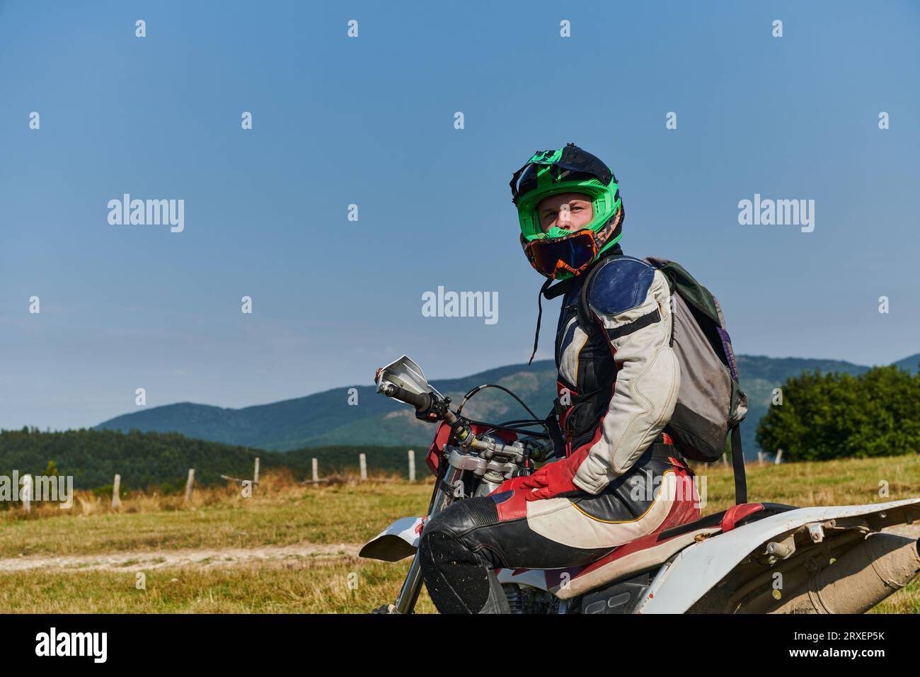 A professional motocross rider, fully geared up with helmet, gloves ...