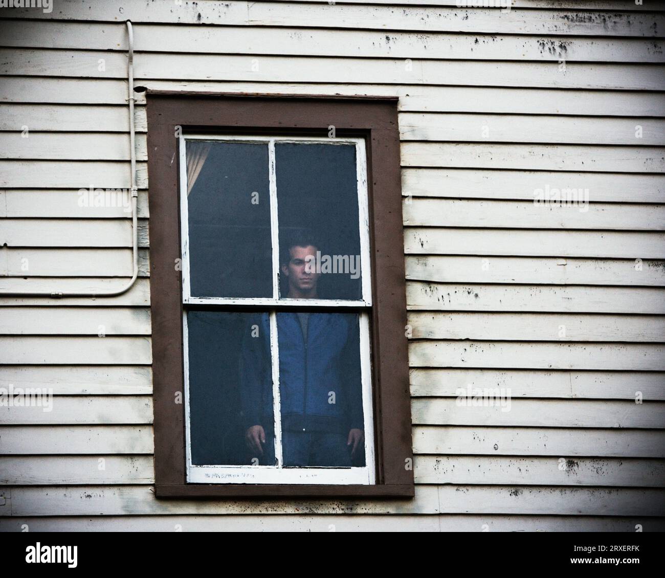 A man standing in window of old house Stock Photo - Alamy