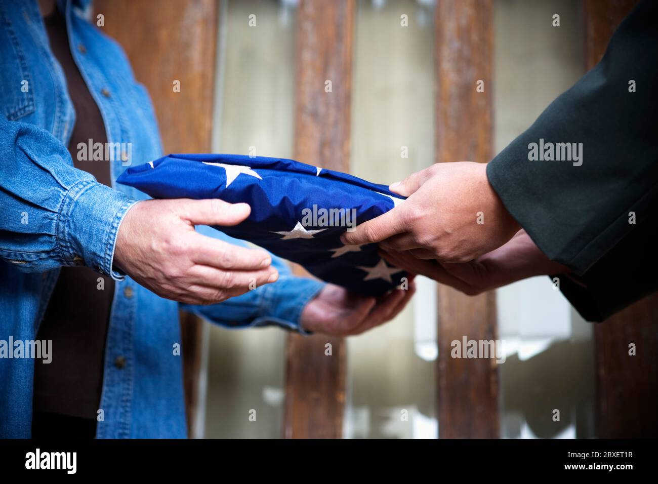 Soldiers hands passing a folded American flag to another person Stock ...