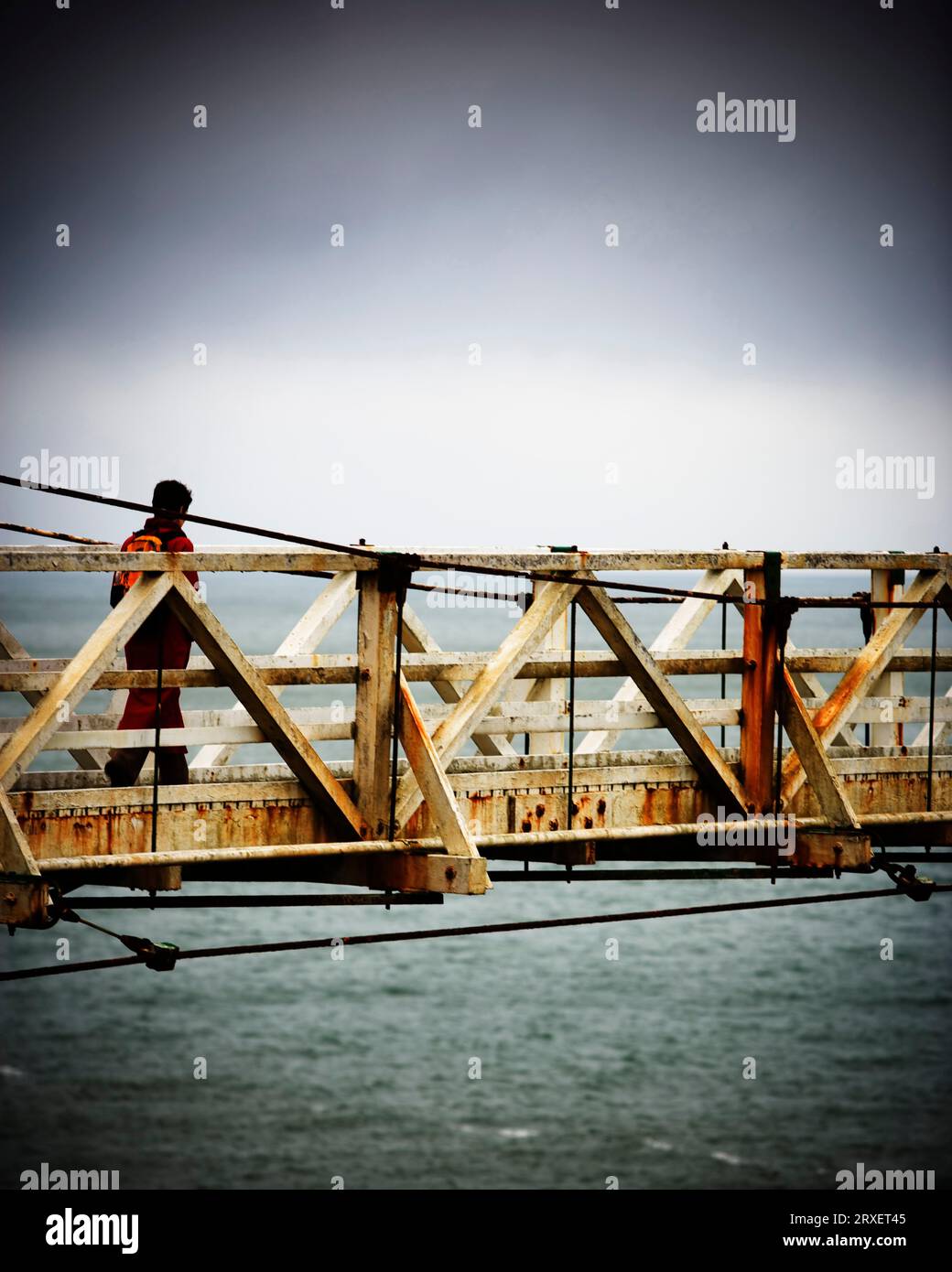 Side view of a person crossing the narrow footbridge, San Francisco ...