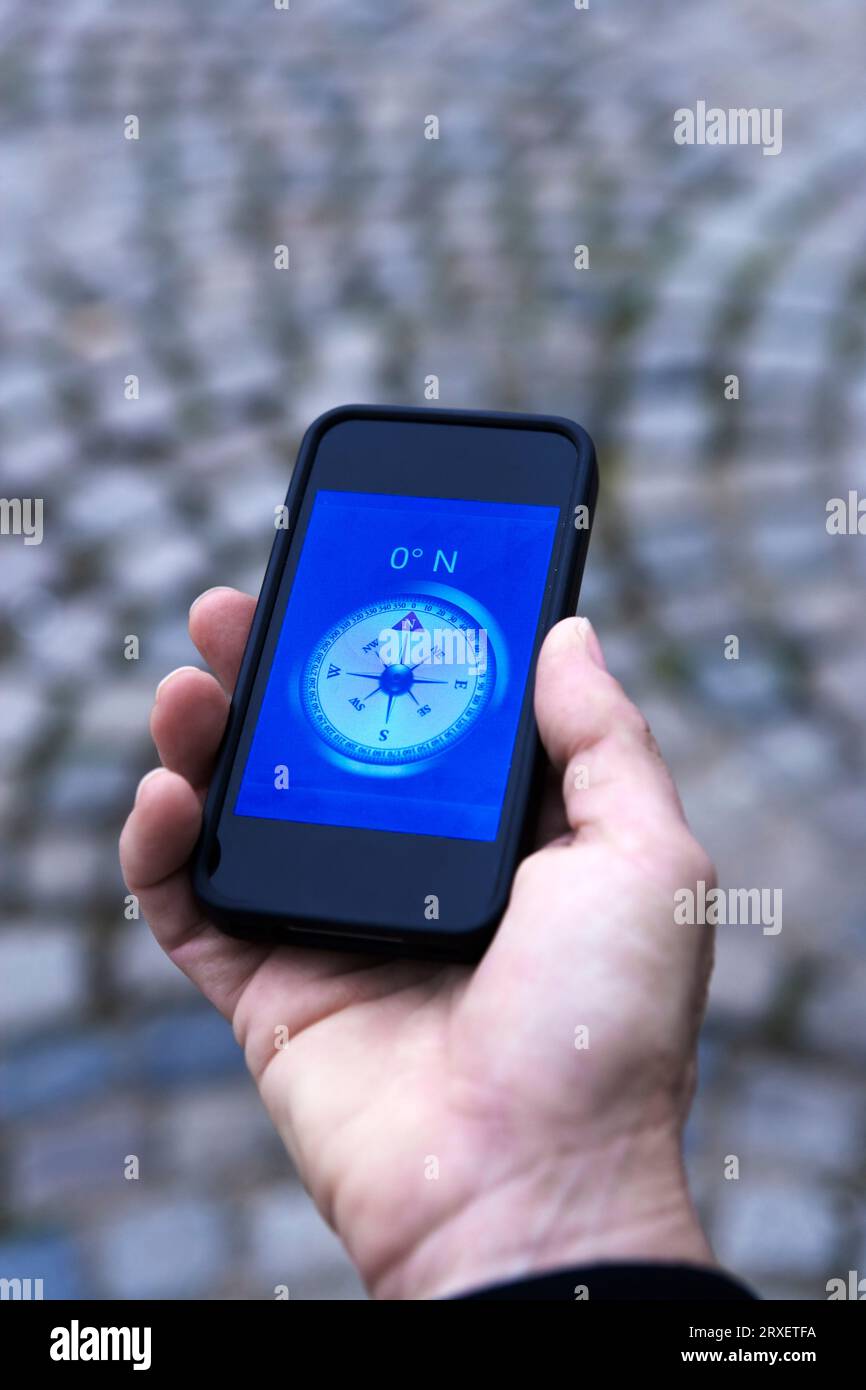 A hand holding a digital compass Stock Photo - Alamy