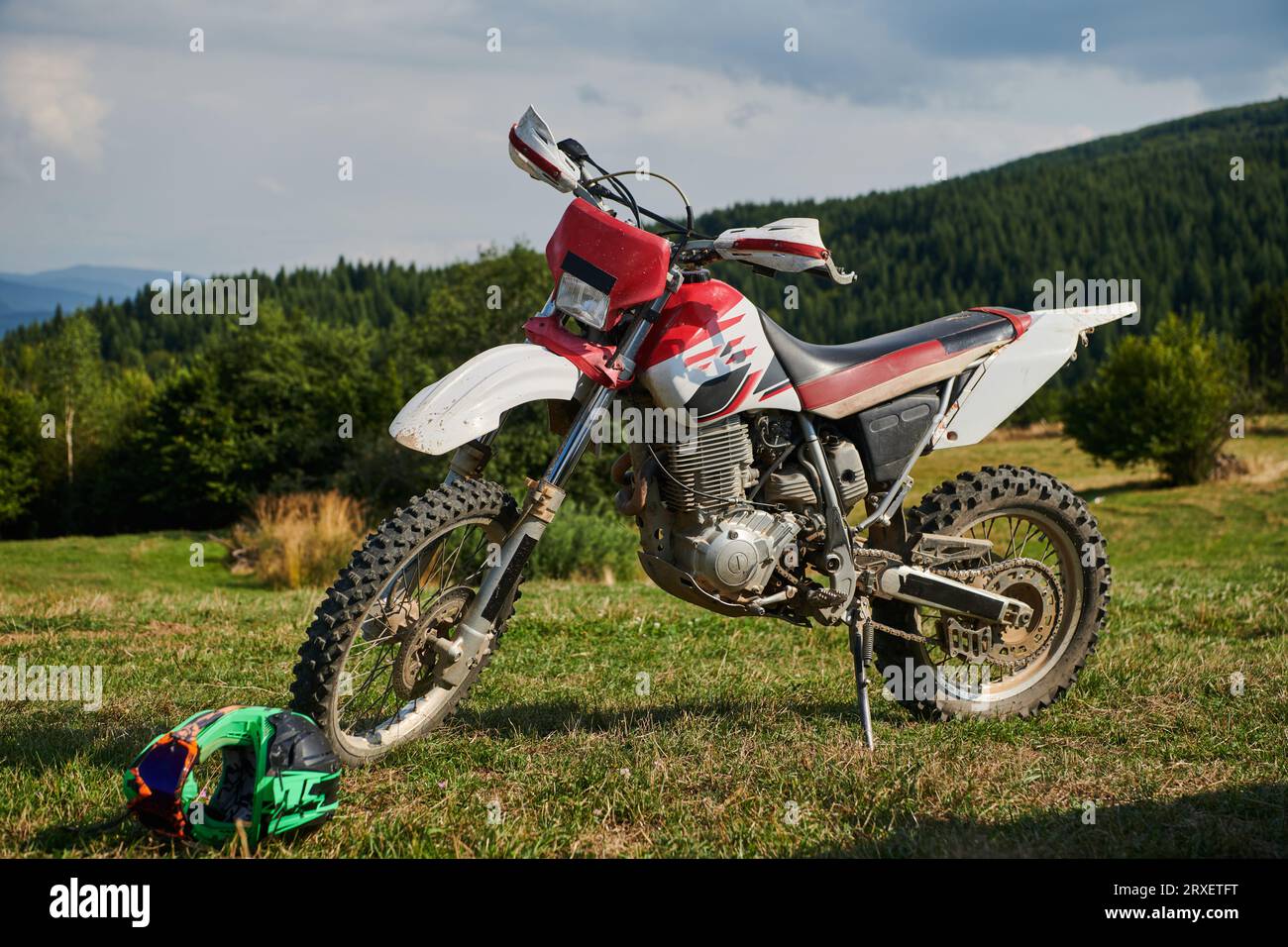 A professional motocross standing poised in a meadow, fully geared up ...