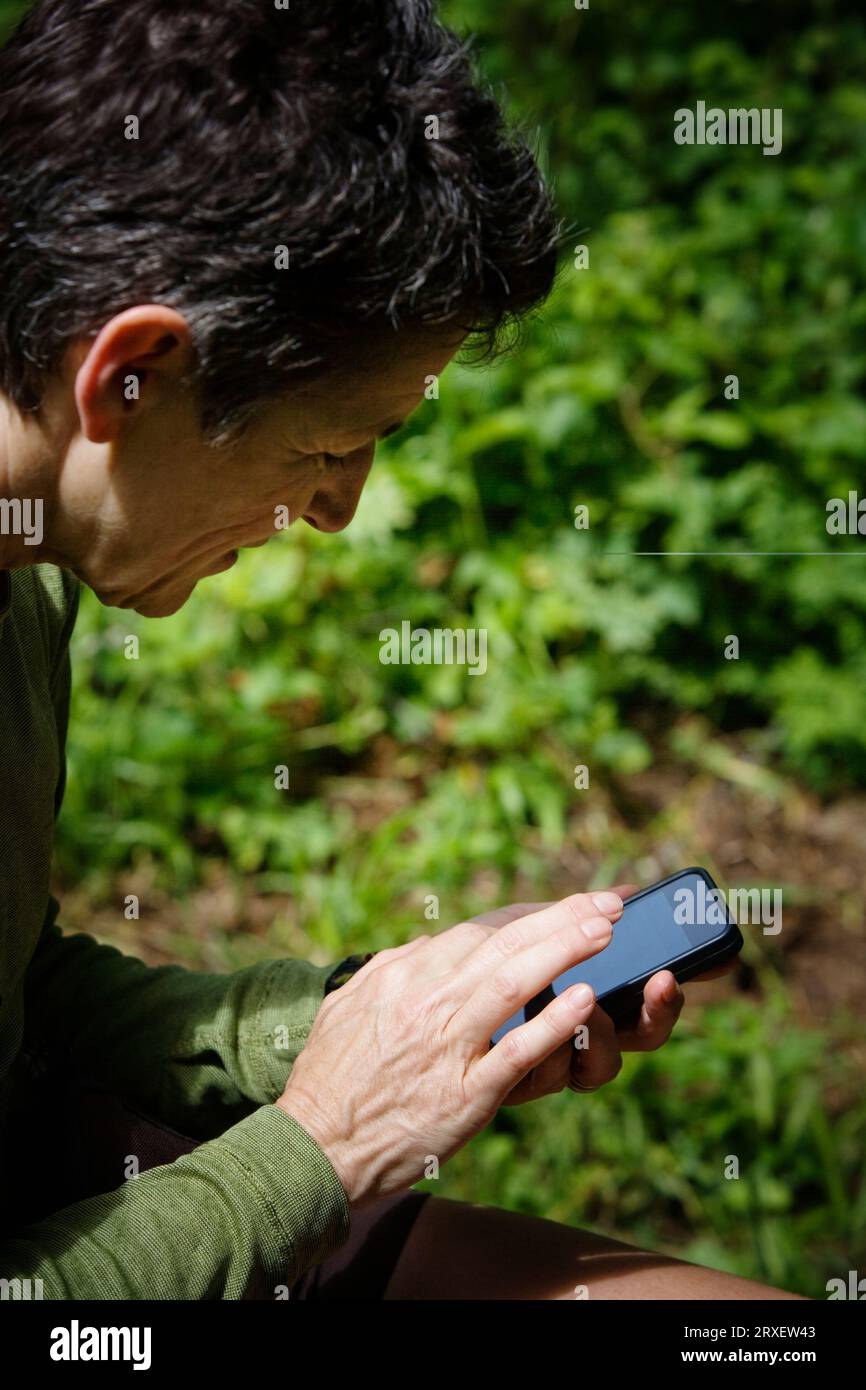 A female hiker checking her cell phone Stock Photo - Alamy