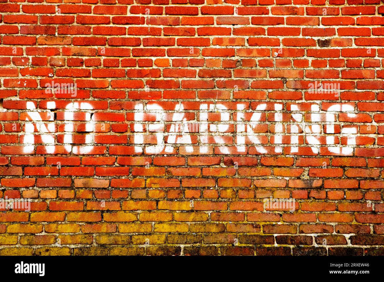 NO BARKING sign painted on the wall of a bright red brick building ...