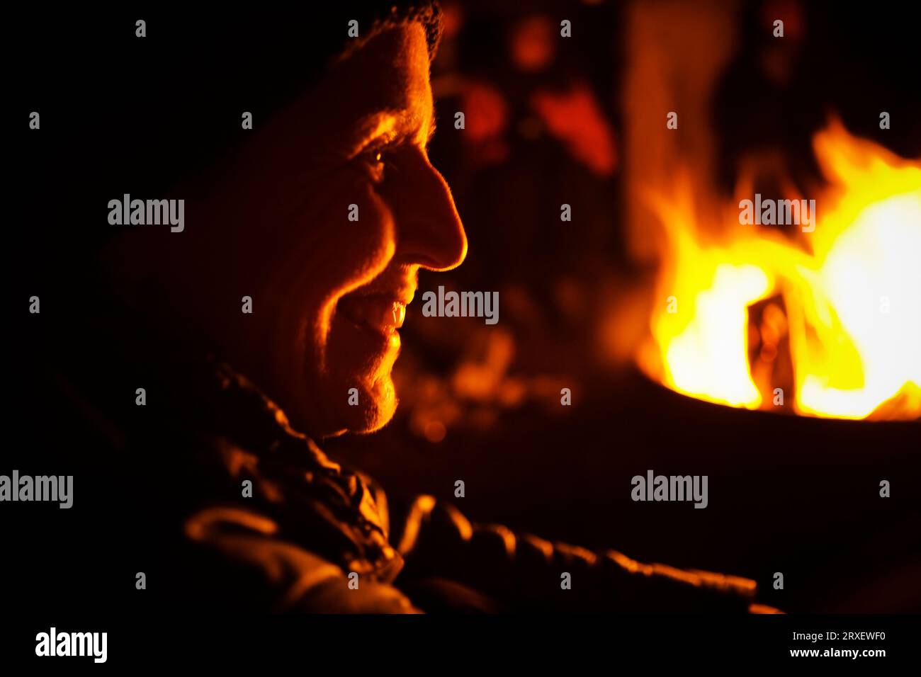 Side view portrait of a woman sitting near an open wood fire Stock ...