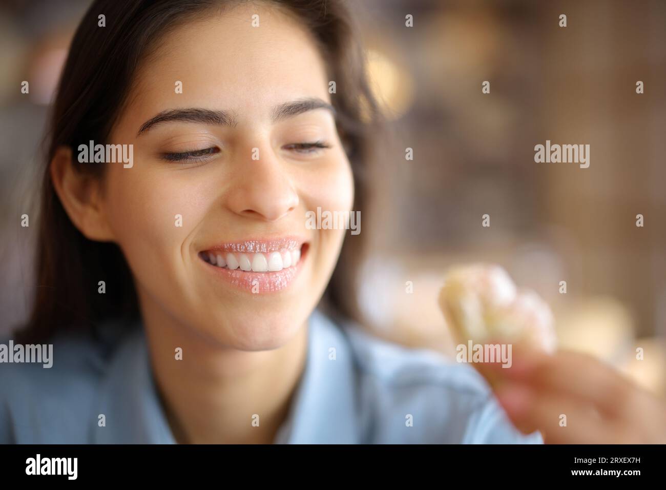 Happy woman eating sweet croissant with dirty lips in a restaurant ...