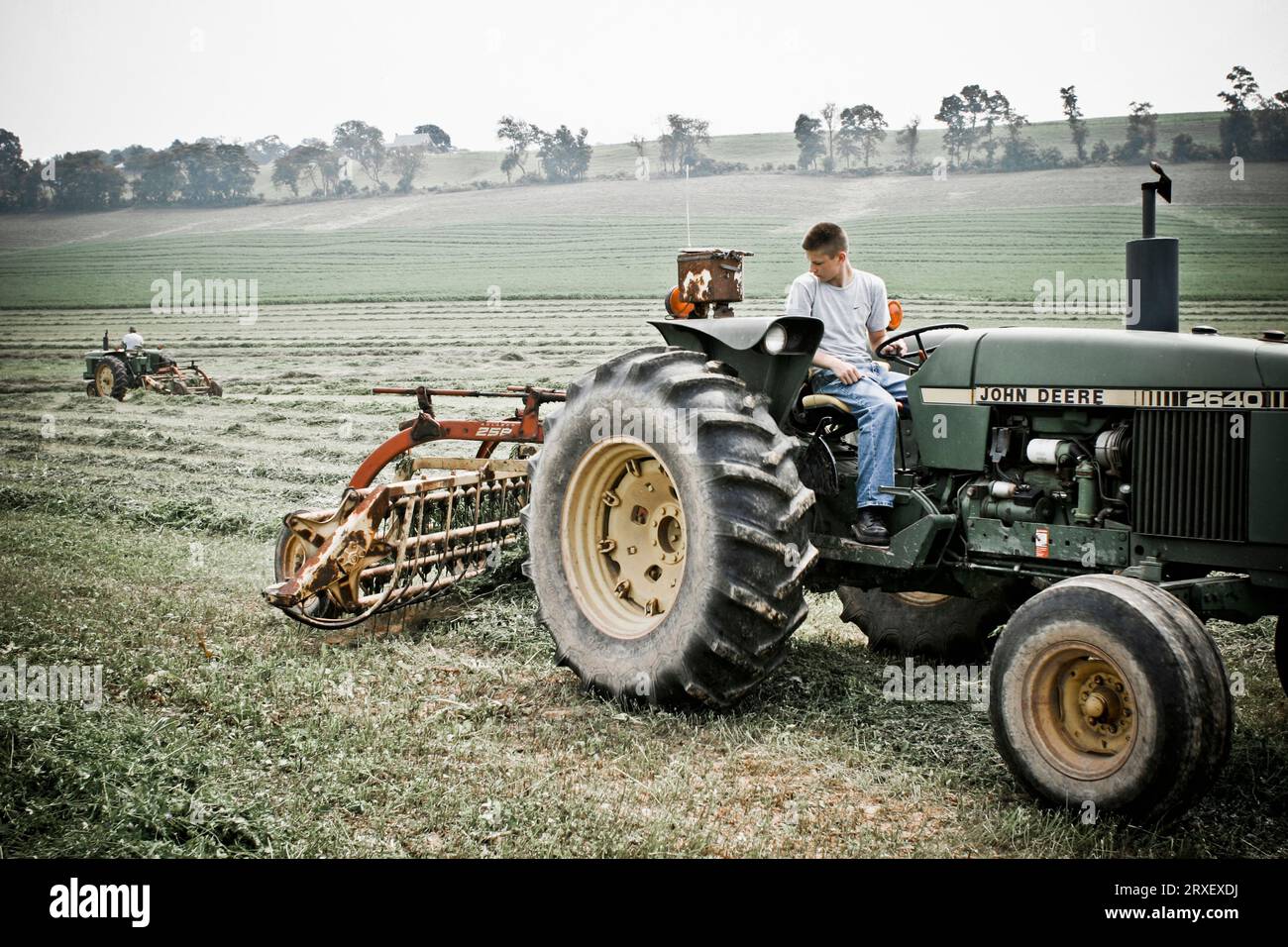 A young boy learns to operate the tractor on his family's dariy farm in ...