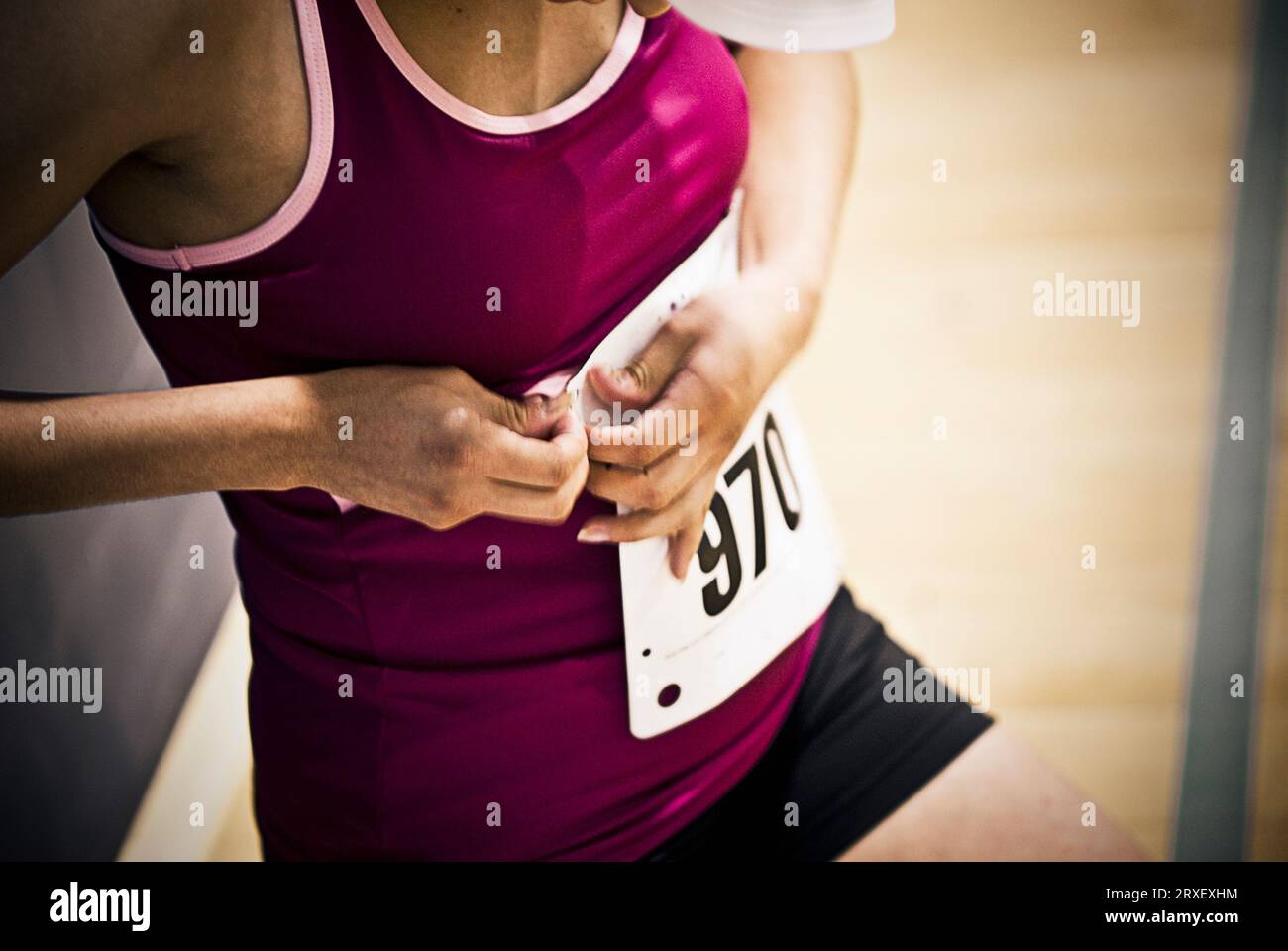 A female runner pins up her number for a 10K road race. Herndon, VA ...