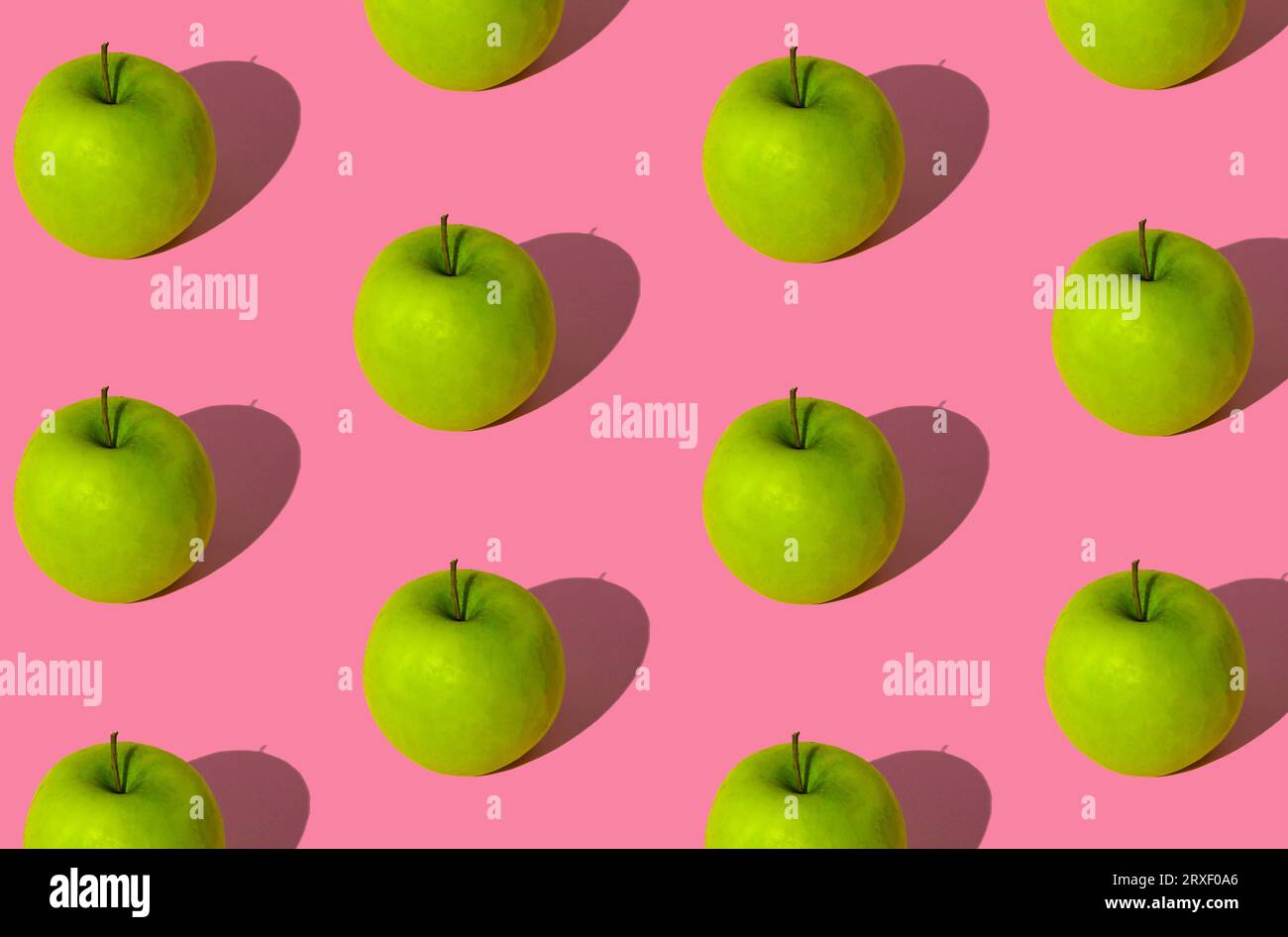 Trendy fruit pattern made of green apples on light pastel pink ...