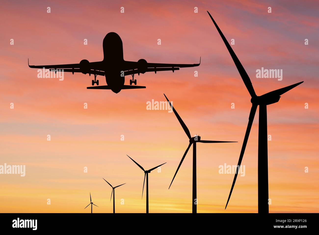 Silhouette of landing plane with wind turbines. Clean mobility concept ...