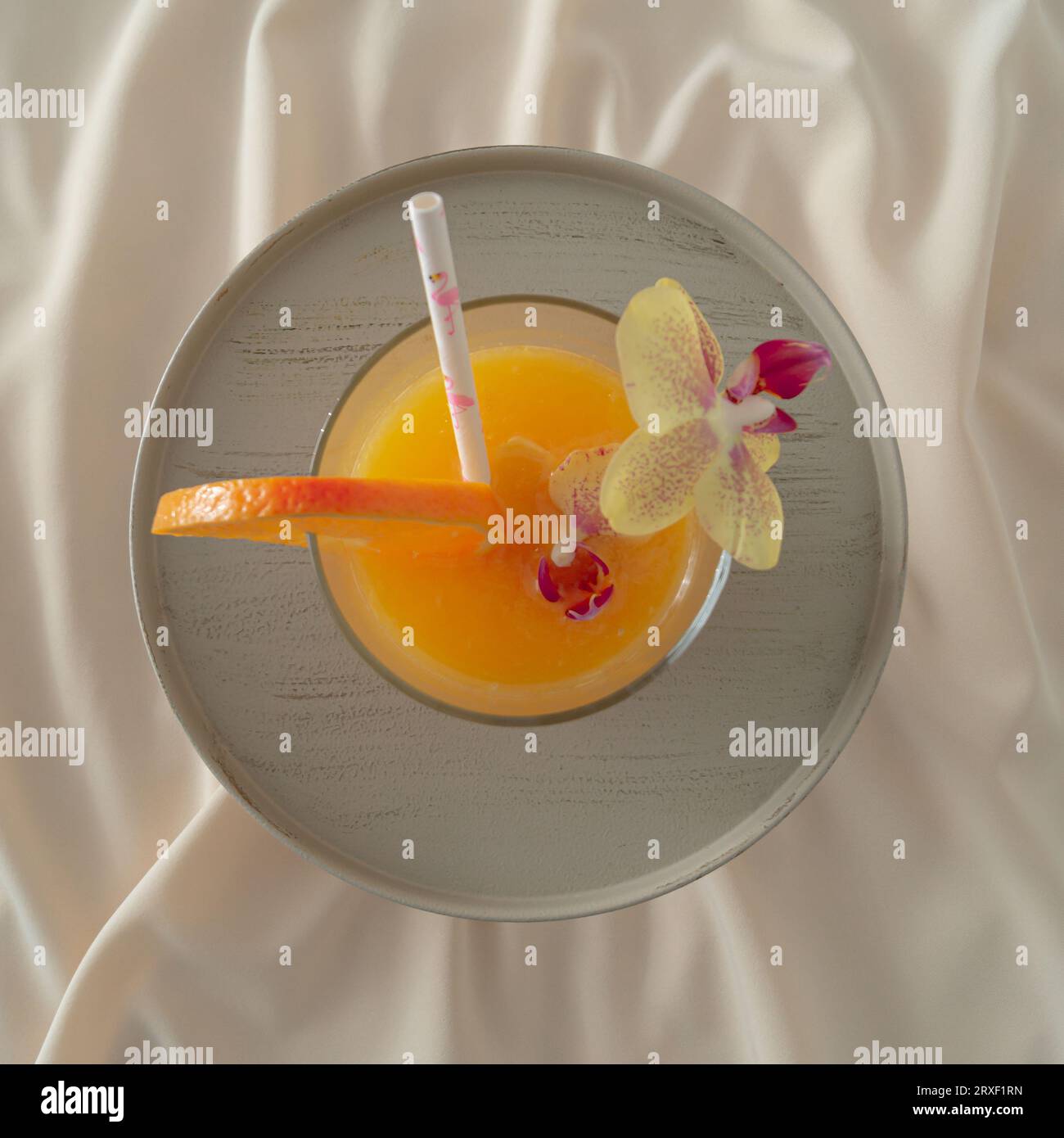 Summer tropical orange juice cocktail on sandy silk background. Minimal ...