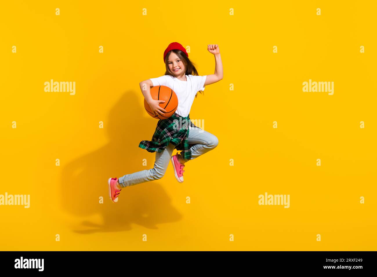 Full length photo of charming little girl run jump raise fist ...