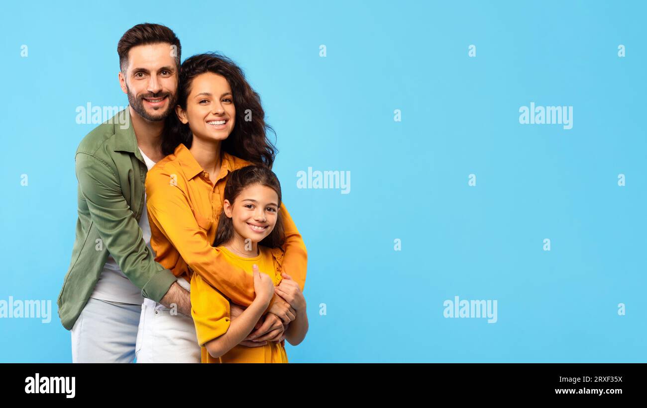 Loving happy european family of three embracing and smiling at camera ...