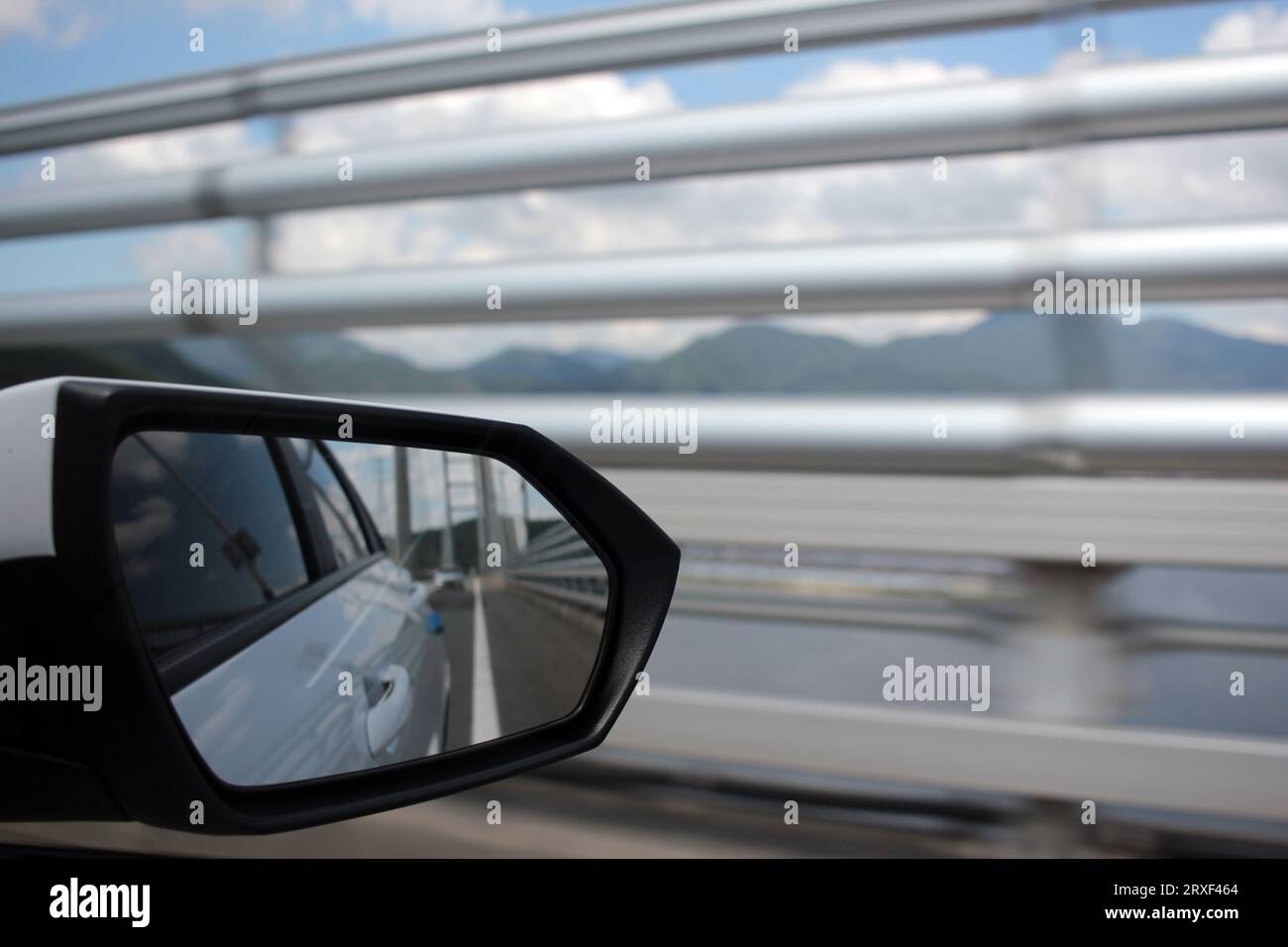 look in the rear view mirror of a car; Machang Bridge, a toll road ...