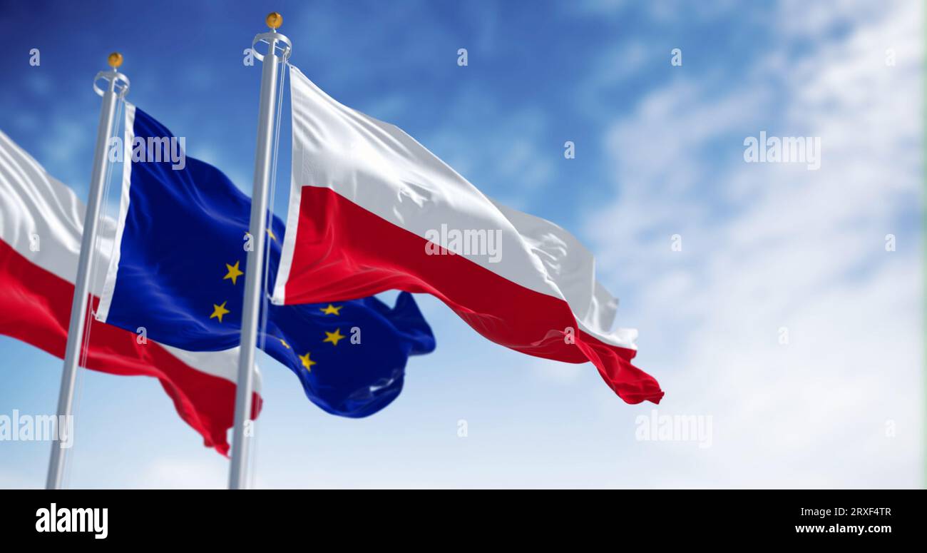 Flags of Poland and the European Union waving in the wind on a clear ...