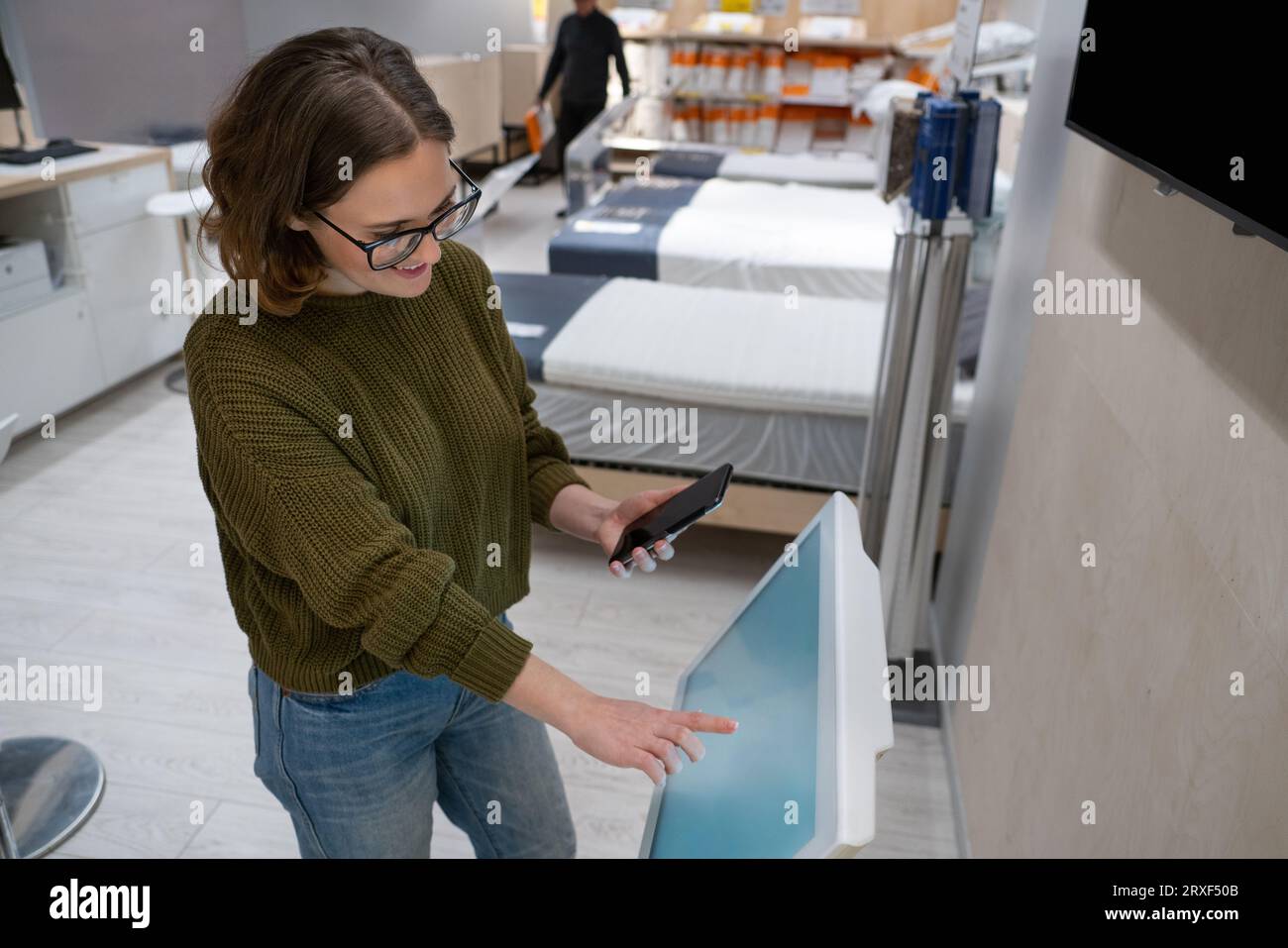 Woman with phone uses self-service kiosk in the shopping mall Stock ...