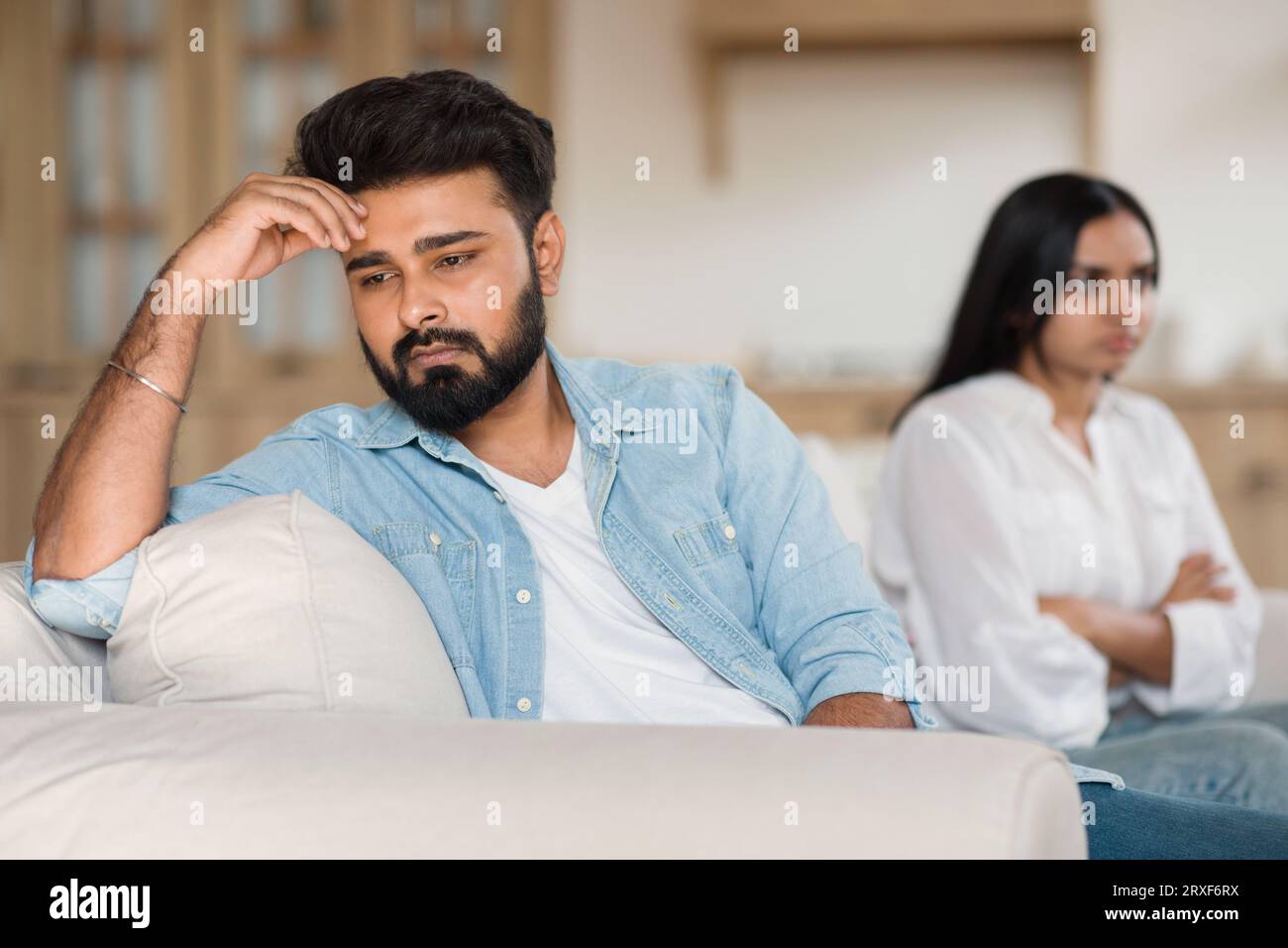 Family problems. Unhappy indian man sitting separate from discontented ...